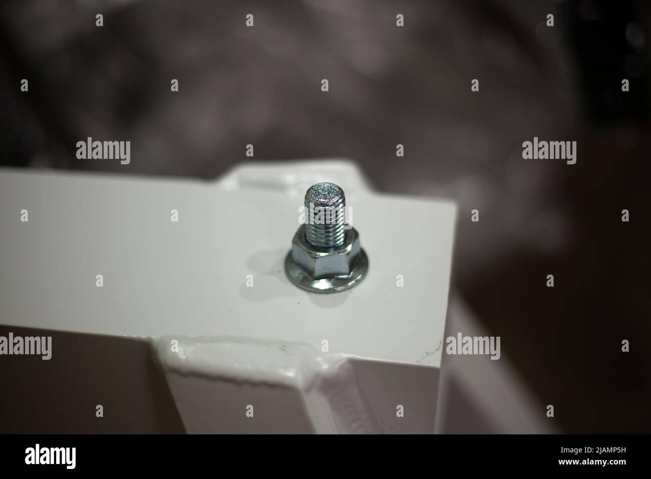 Nut screwed on bolt. Fastening of part. White construction. Finished ...