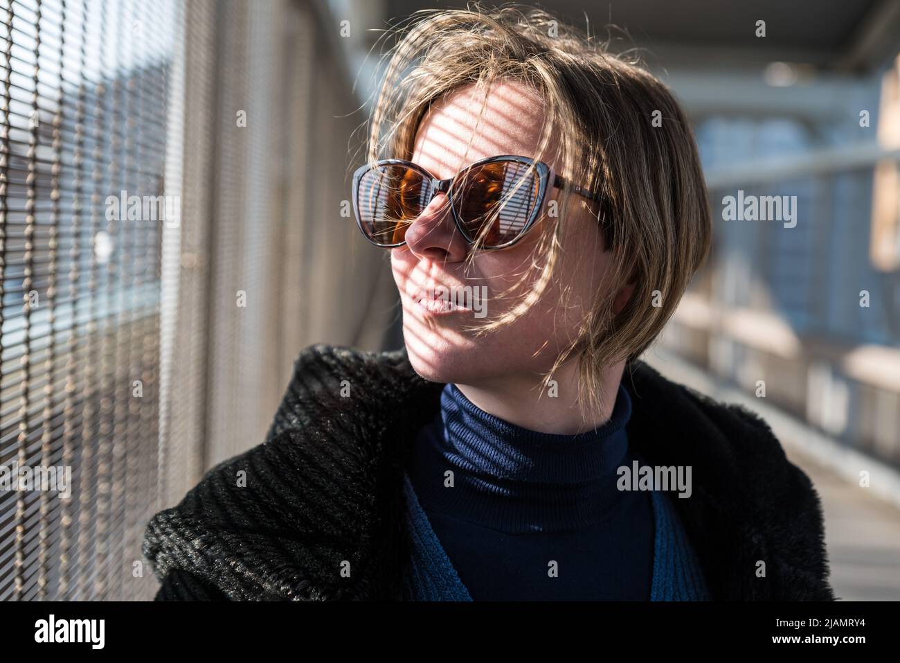 Attractive thirty year old woman with hard shadow lines on her face and ...