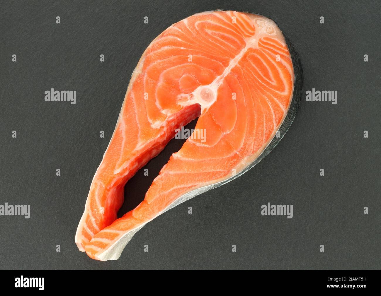 Fresh raw Salmon fish steak on black stone background close-up Stock ...