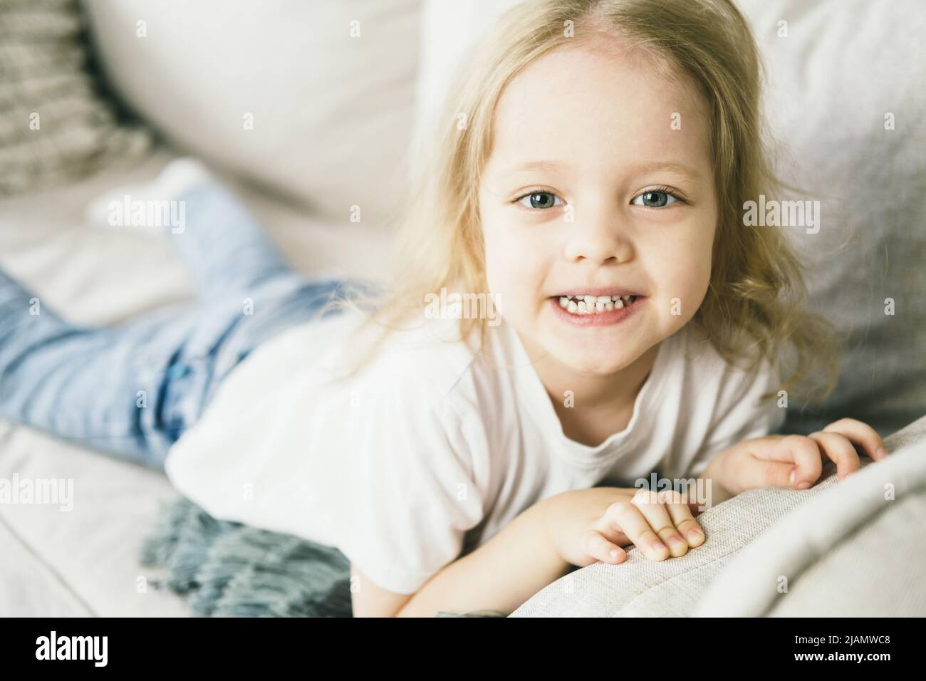 Baby with blond hair shows white teeth Stock Photo - Alamy