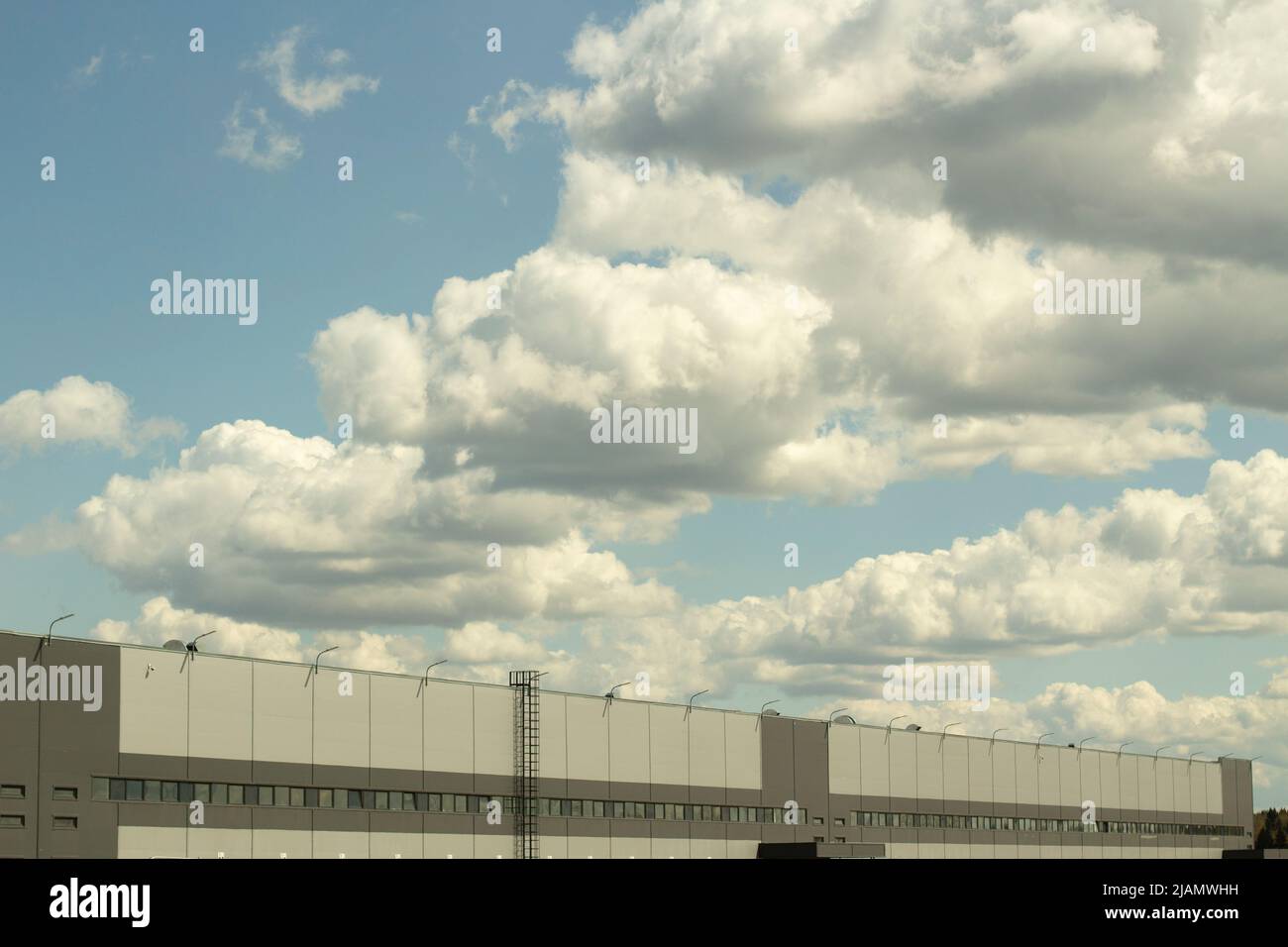 Warehouse and sky. Grey building. Clouds over the warehouse. Modern ...