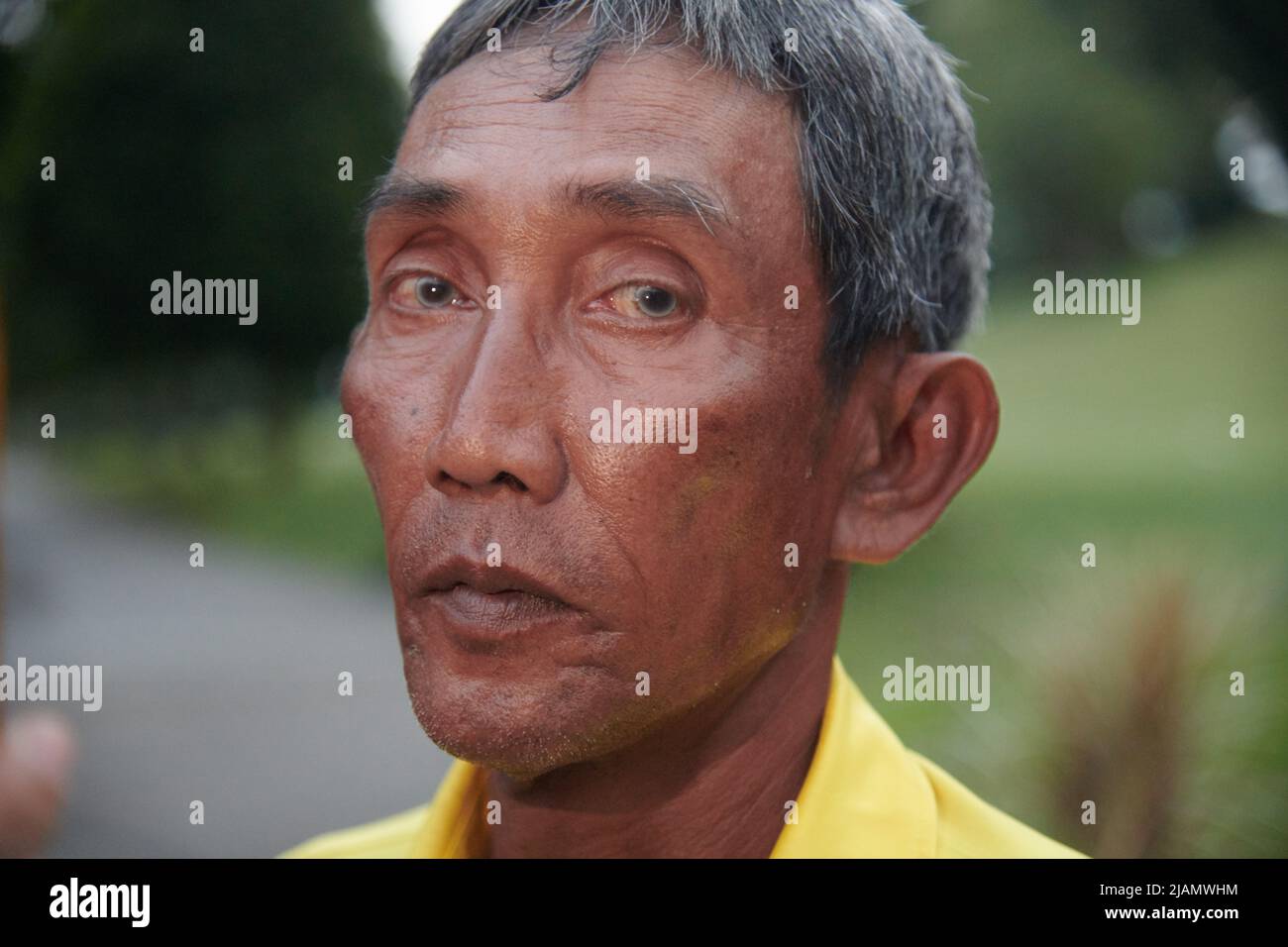 Portrait of an elderly Malay man with piercing blue eyes looking ...