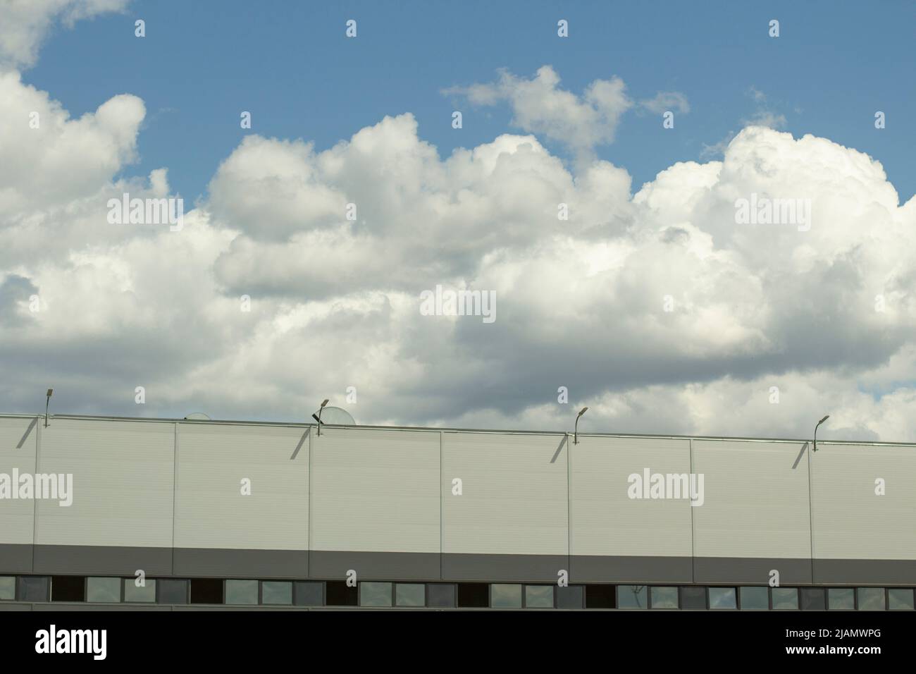 Warehouse and sky. Grey building. Clouds over the warehouse. Modern ...