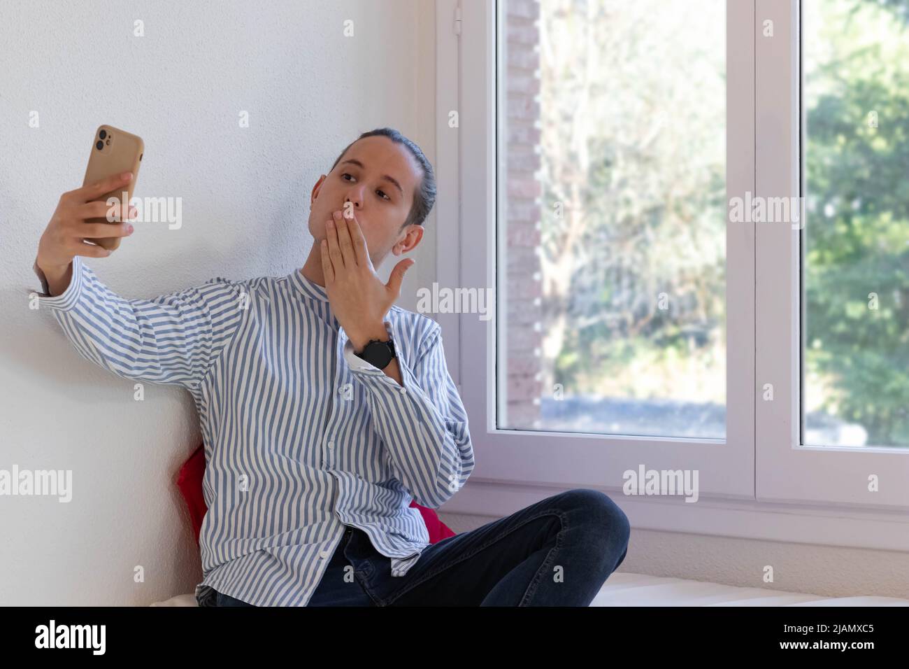 Young man making a video call with his girlfriend and sending an air ...
