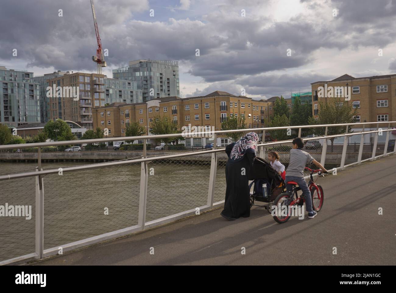 Muslim family walking by ew housing developments and old pier in ...