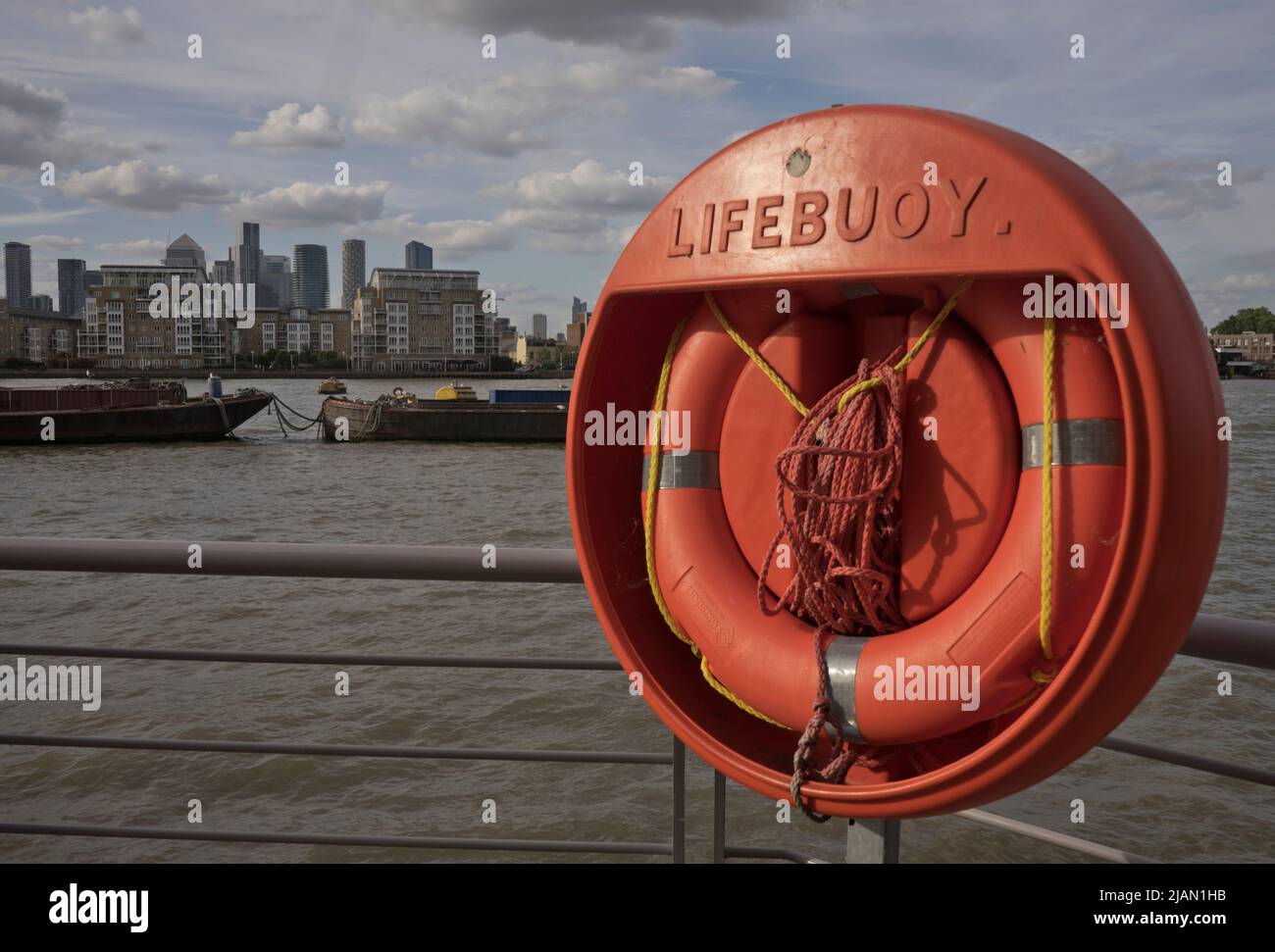 Lifebuoy by new housing developments and old pier by river Thames in ...