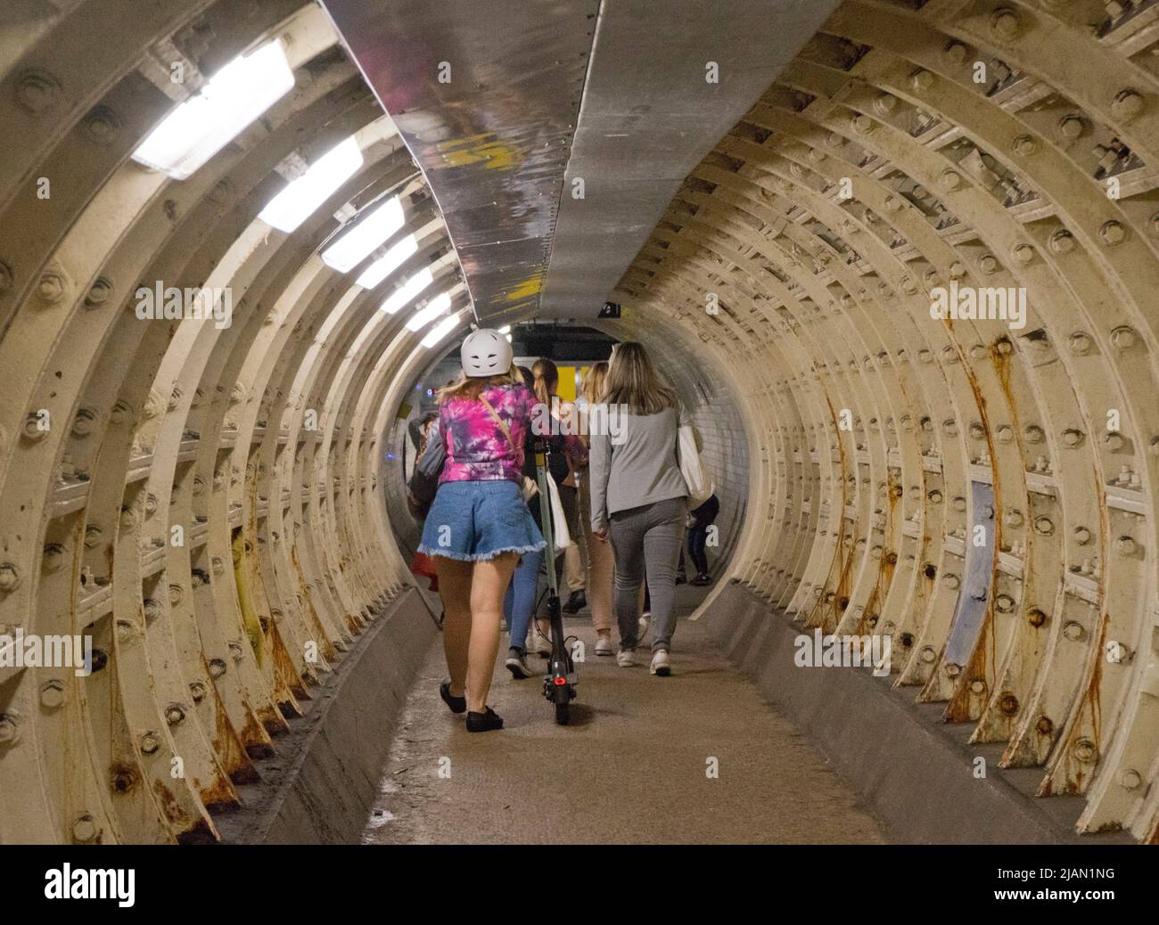 People walking and cycling along tunnel under river Thames in Greenwich ...