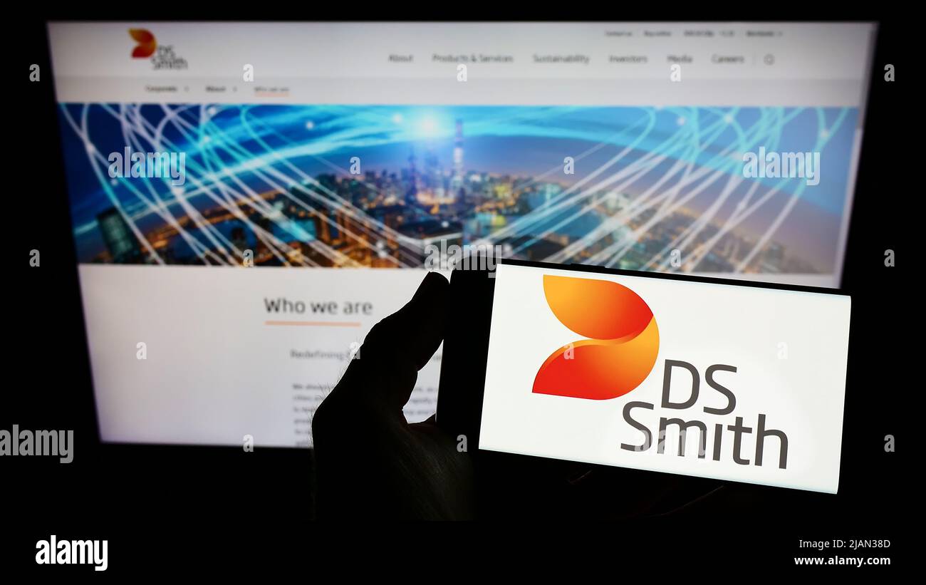 Person holding smartphone with logo of British packaging company DS ...