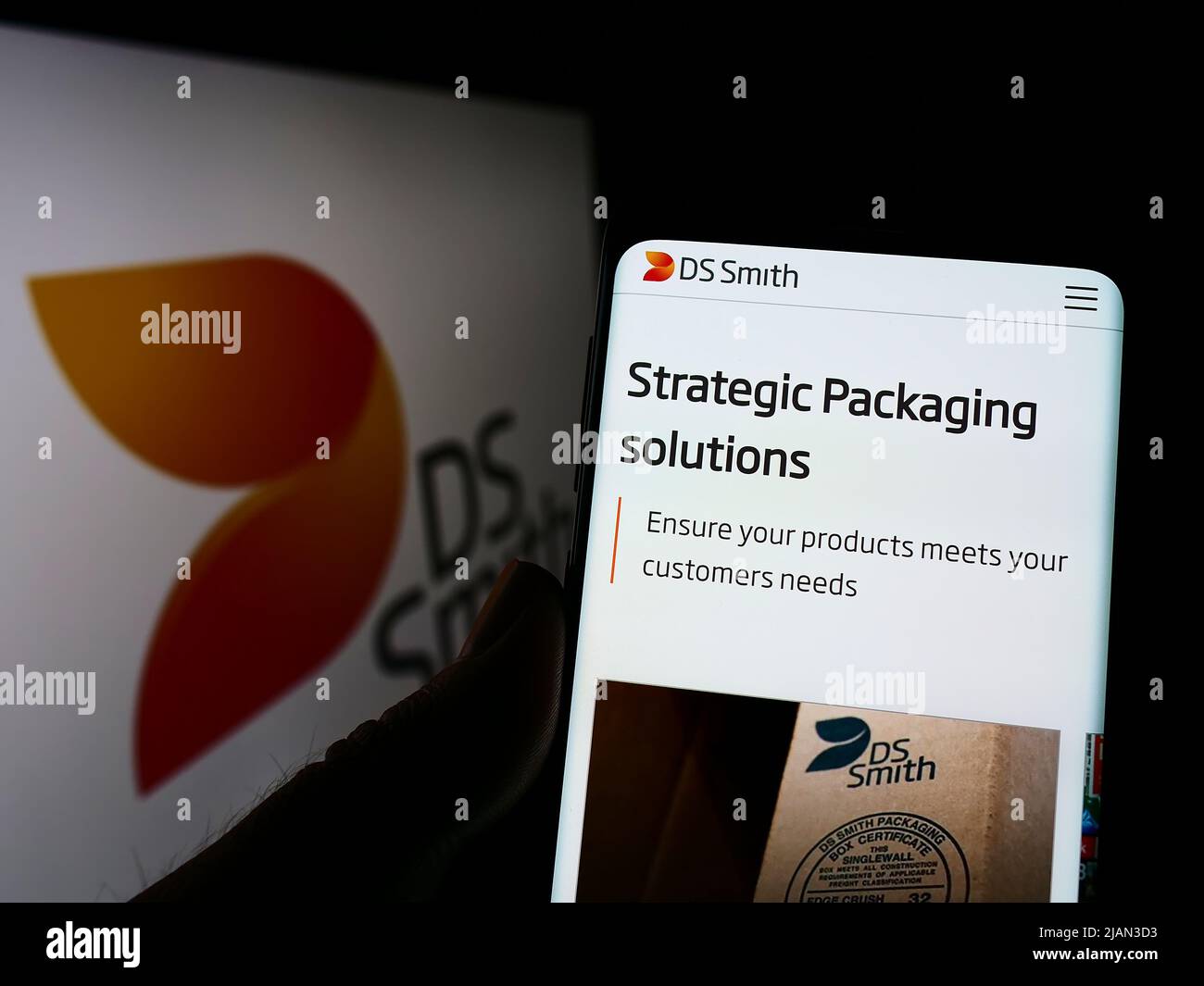 Person holding cellphone with webpage of British packaging company DS ...