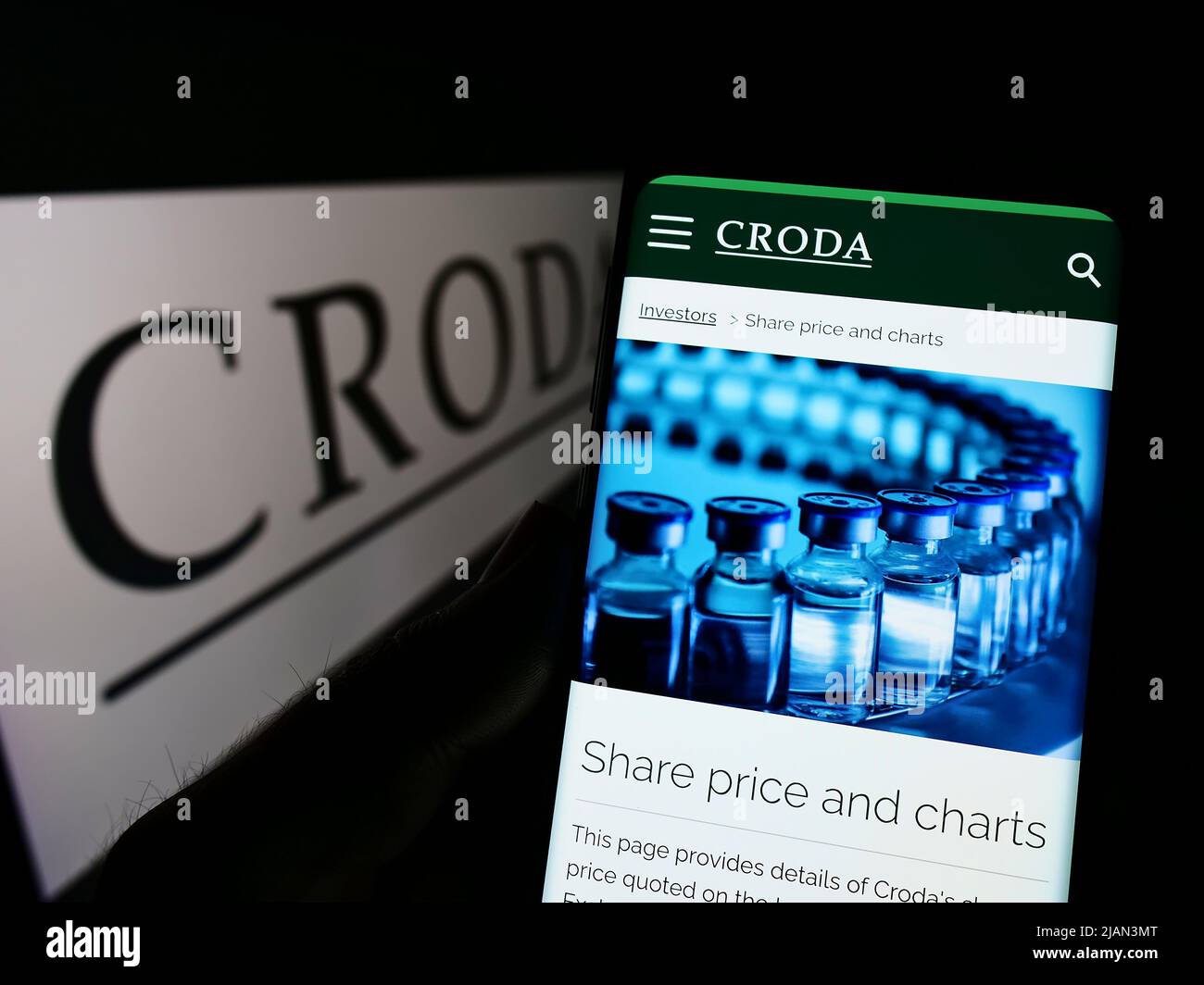 Person holding cellphone with webpage of chamicals company Croda ...