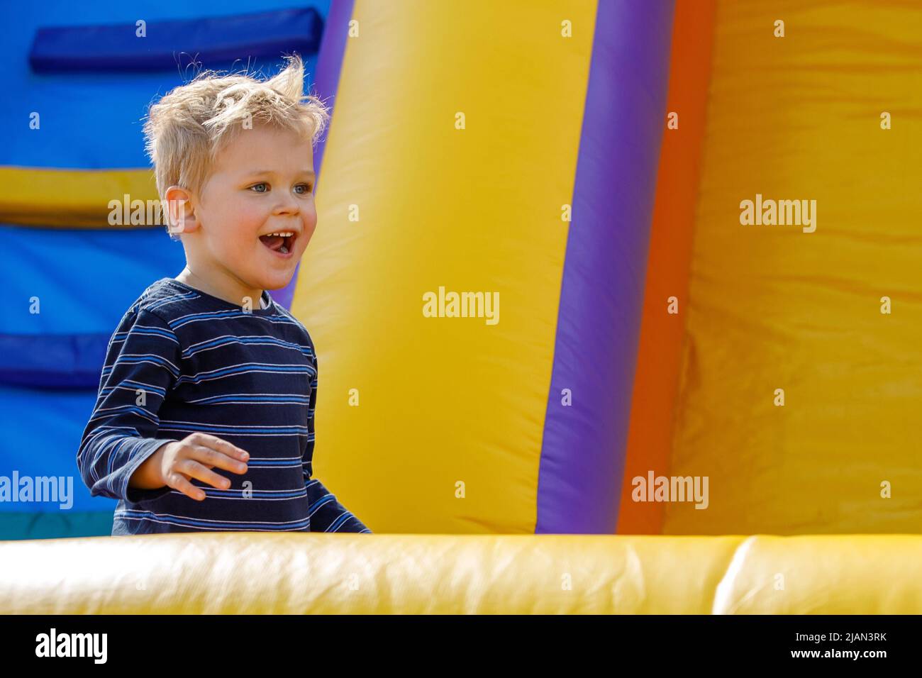 Smiling little boy playing outdoors on an inflatable bounce house Stock ...