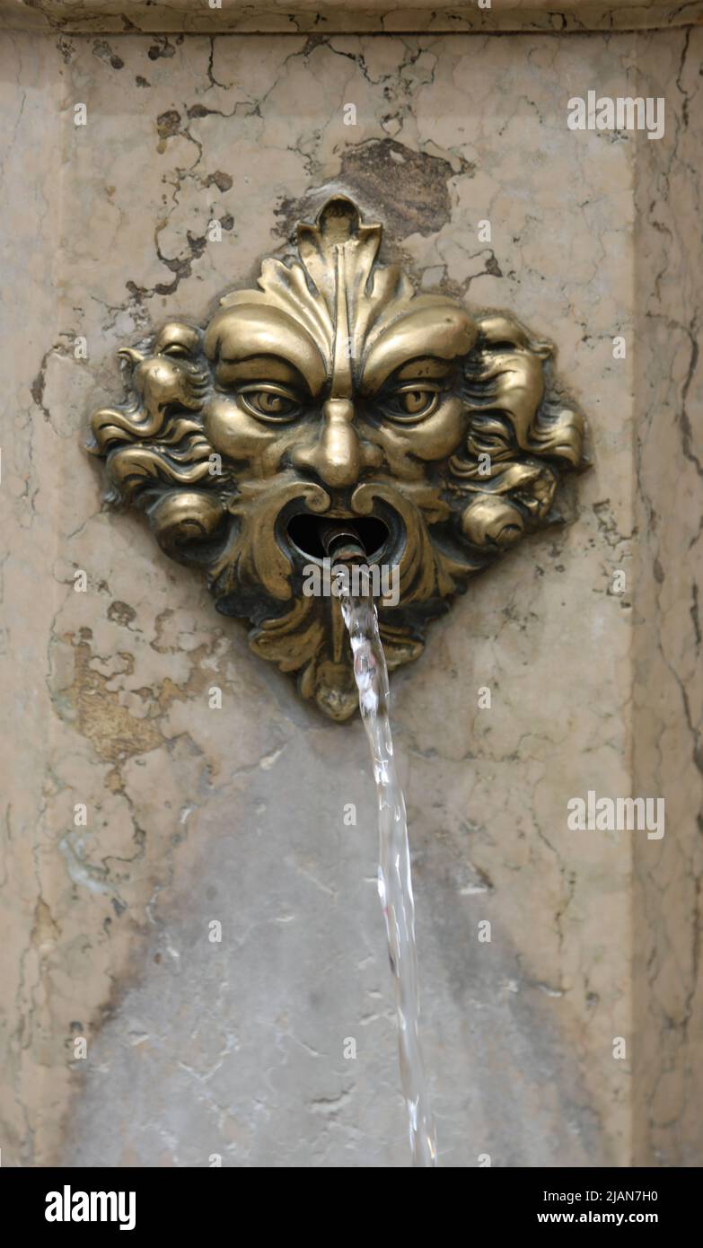 Face of a brass monster in a fountain from which drinking water comes ...