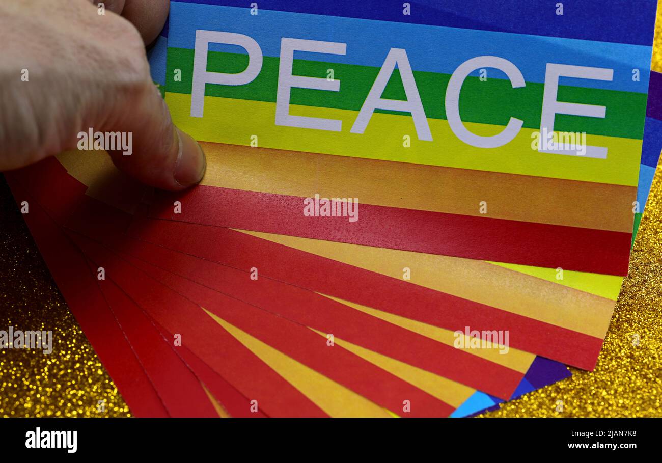 Hand of man holding the flags of Peace as if it were playing cards ...