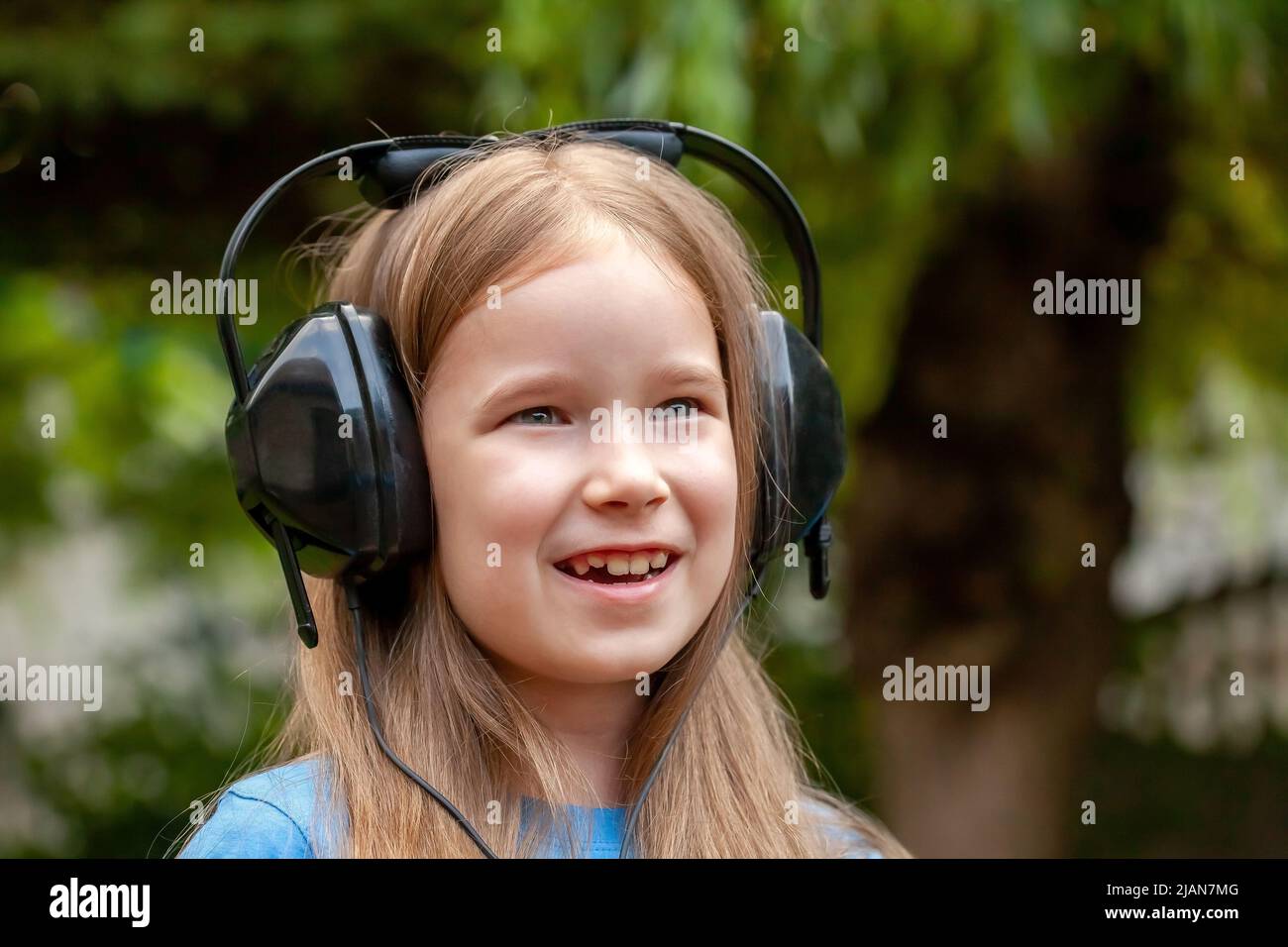 One single happy cheerful school age child, girl wearing large ...