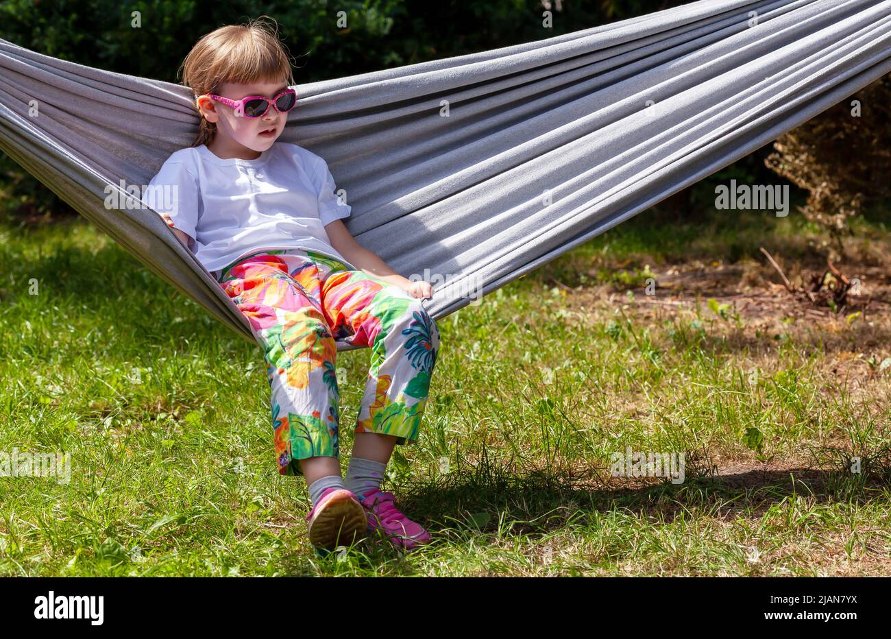 One single school age girl, child in sunglasses and colorful clothes ...