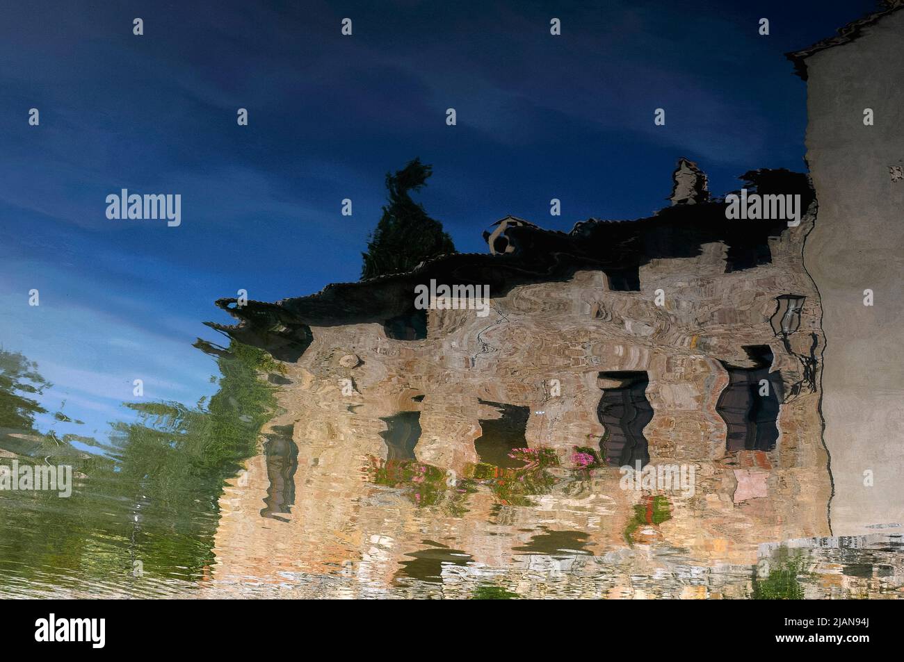 Honey-coloured stone buildings reflected in hot volcanic spring water ...