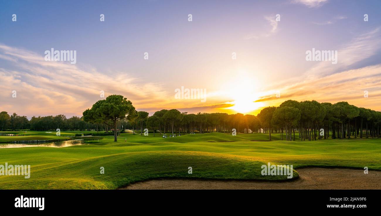 Golf course at sunset with beautiful sky and sand trap. Scenic ...