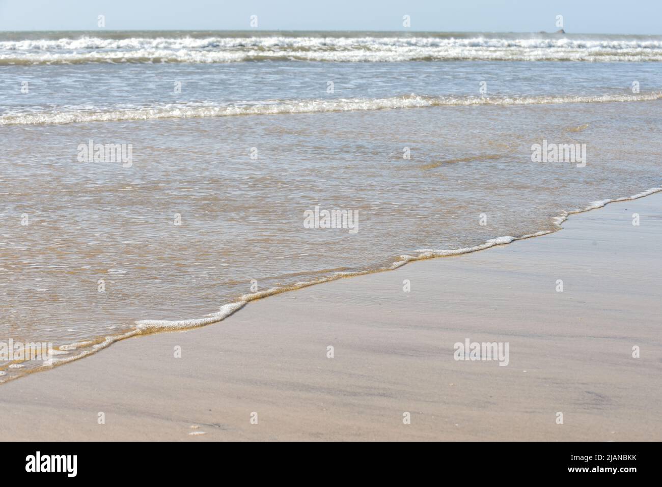 Sea shore with ocean water lapping at the sandy beach Stock Photo - Alamy