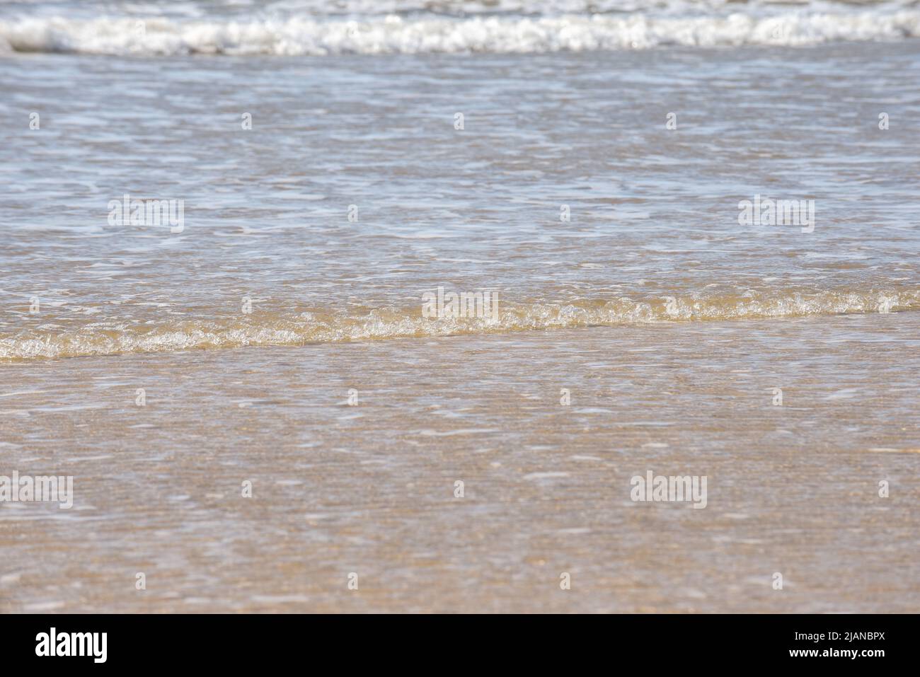 Sea shore with ocean water lapping at the sandy beach Stock Photo - Alamy