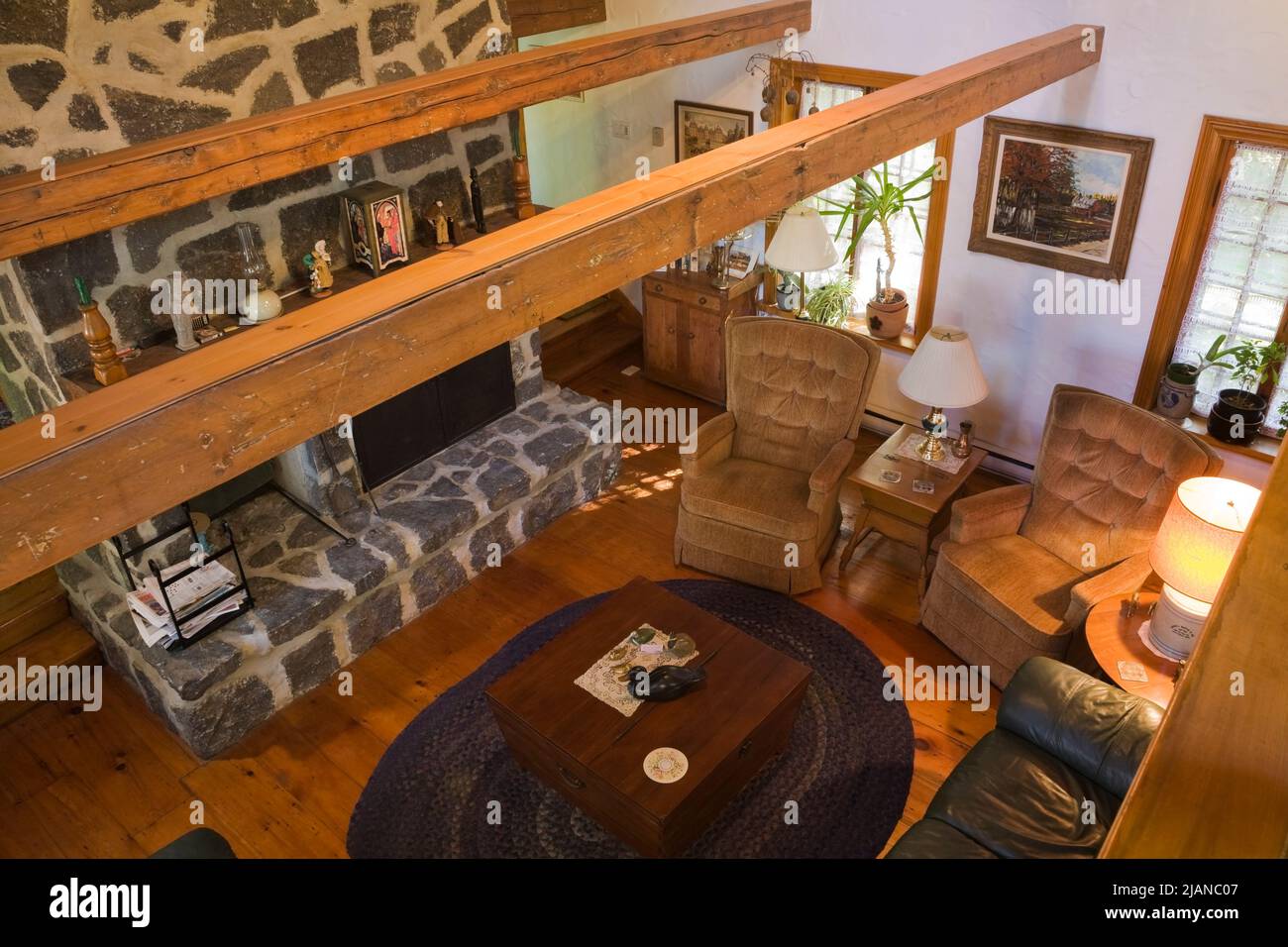 High angle view of living room with natural stone fireplace, rust ...