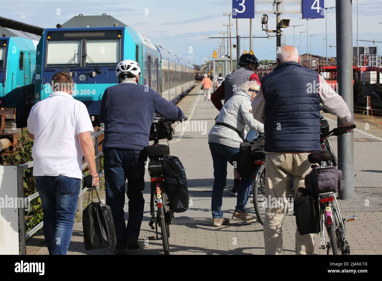 Westerland, Germany. 31st May, 2022. Travelers walk with their bicycles ...