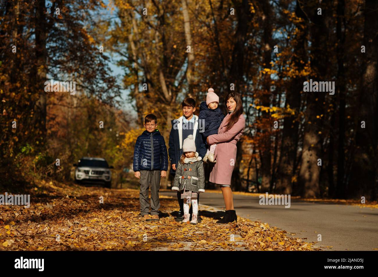Mother with four kids in autumn park. Family walk in fall forest Stock ...