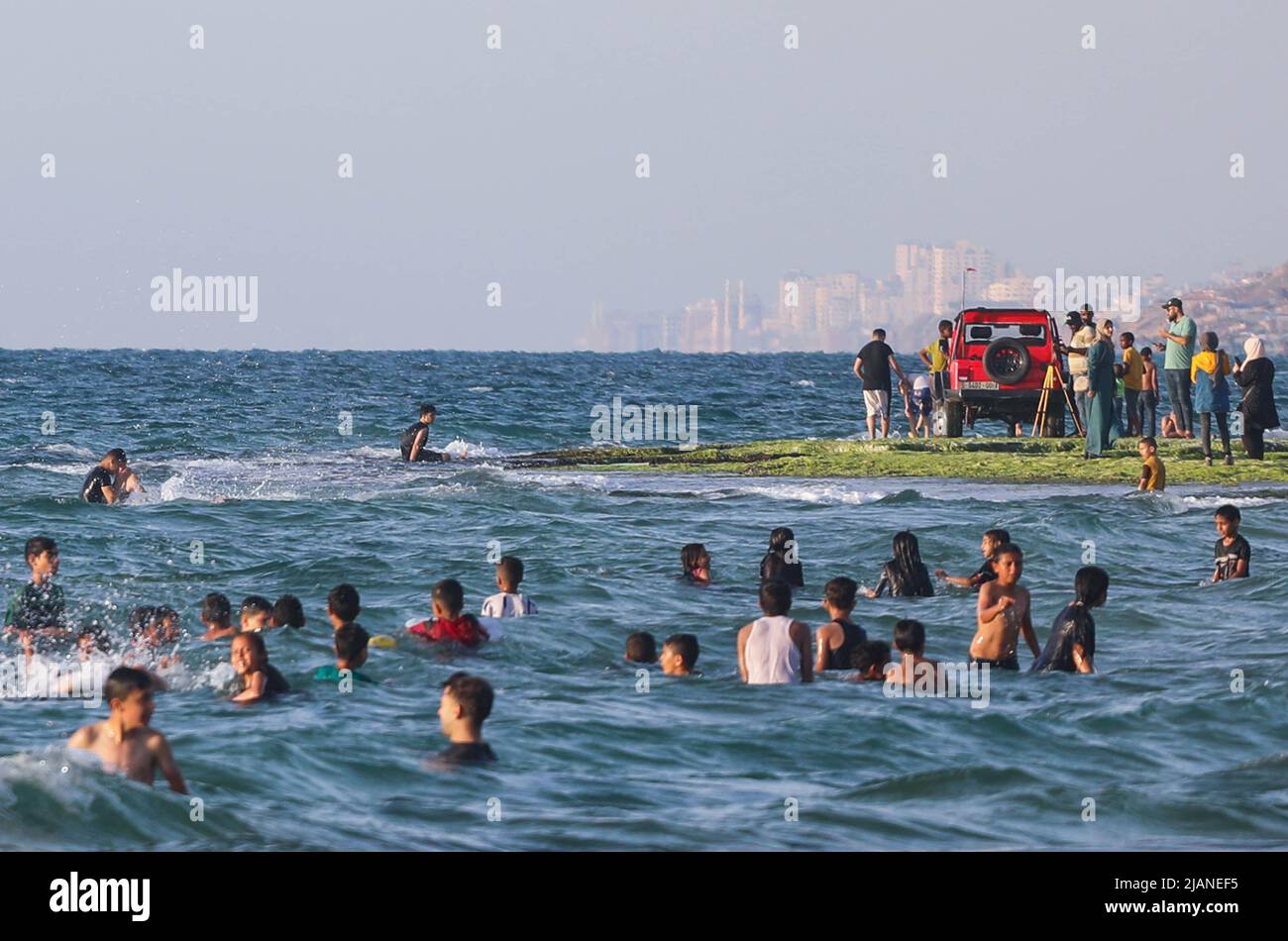 Palestinians swim in the sea on the first day of the school vacation ...