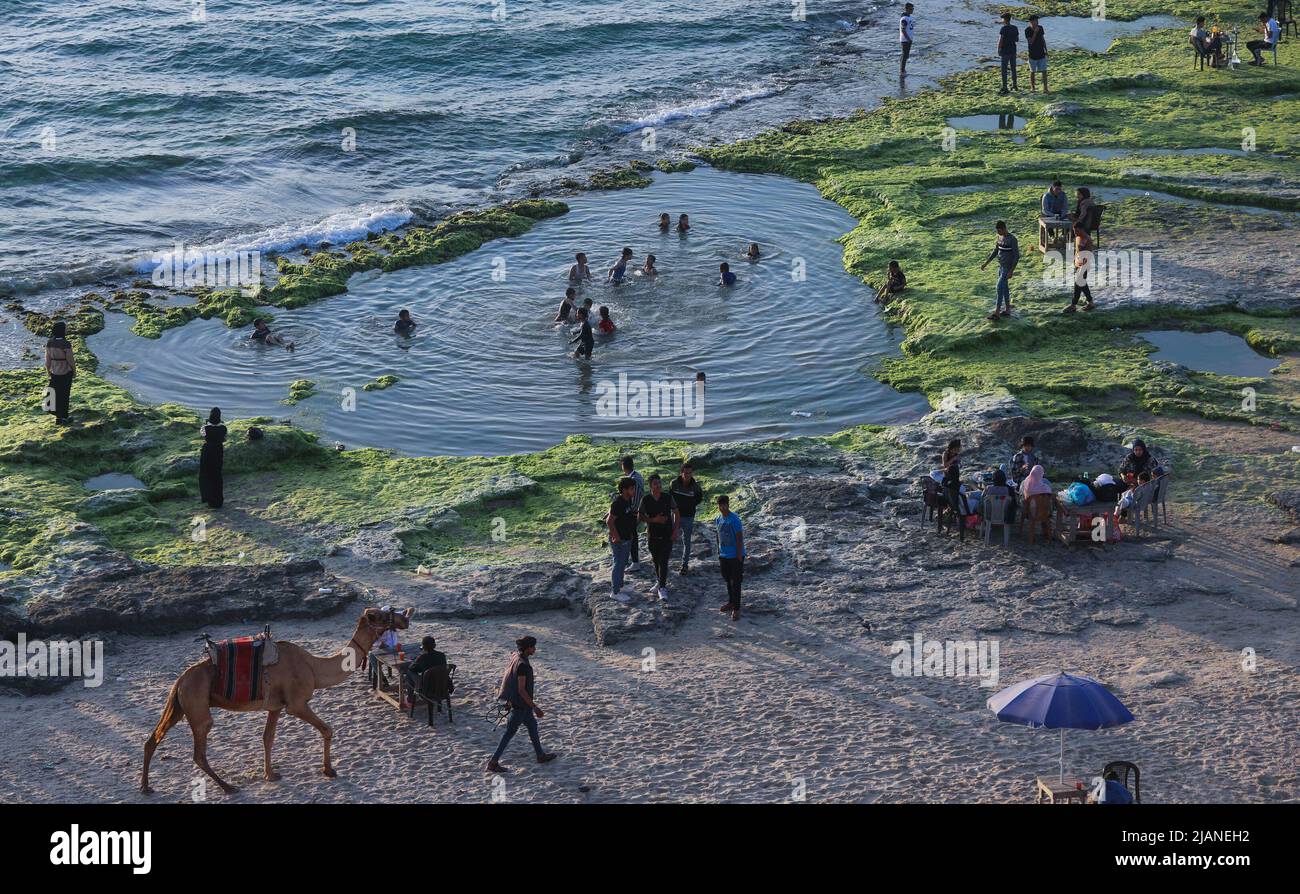 Palestinians enjoy the sea on the first day of the school vacation ...