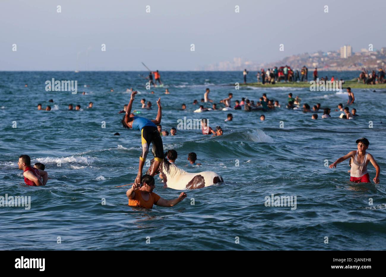 Palestinians enjoy the sea on the first day of the school vacation ...