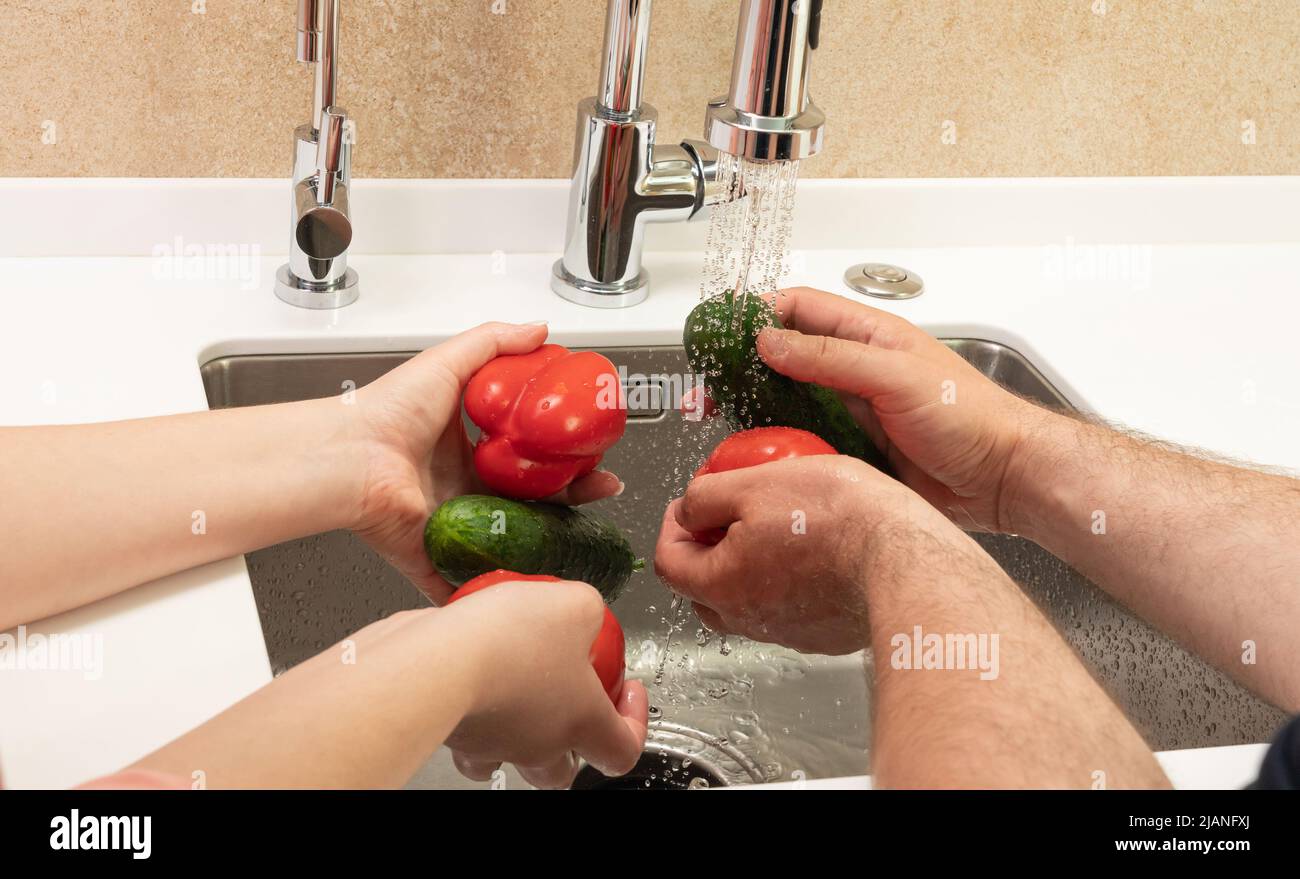 the process of washing vegetables for lunch in the kitchen in the sink ...