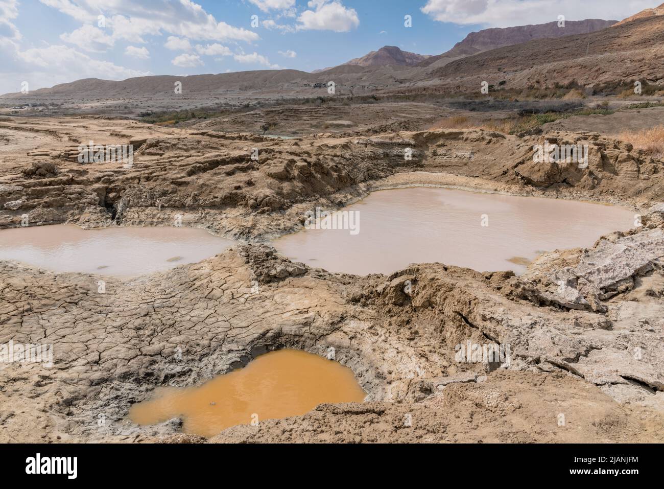 Sinkhole filled with water in different colors, near Dead Sea coastline ...