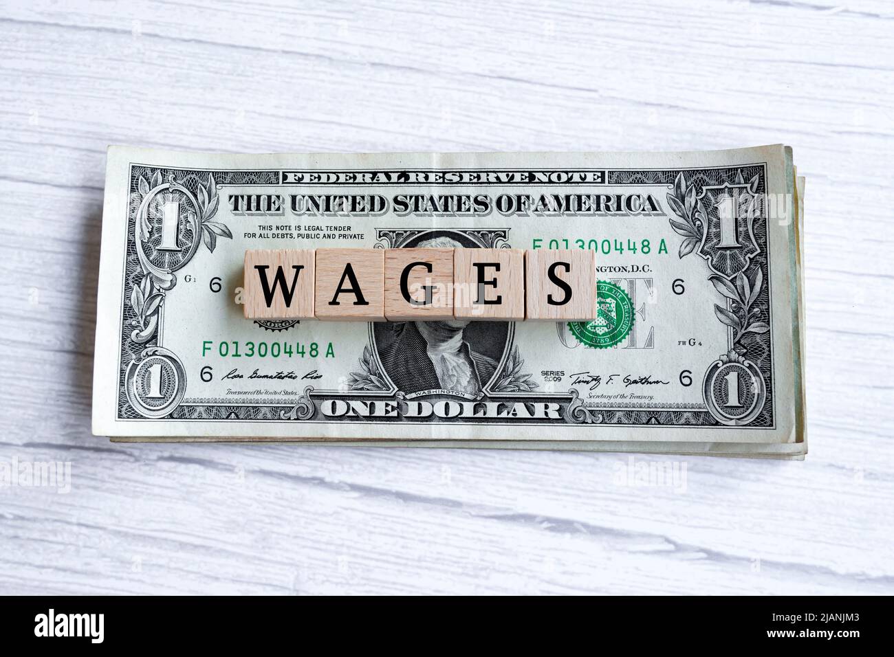 Wages word written on wood block with American Dollar-bills. Directly ...