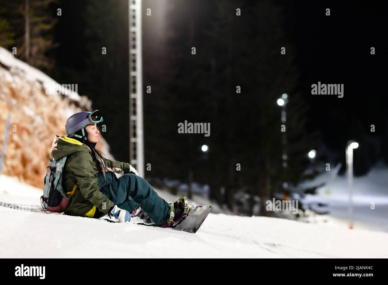 Snowboarder girl posing on slopes. Night skiing in winter resort Stock ...