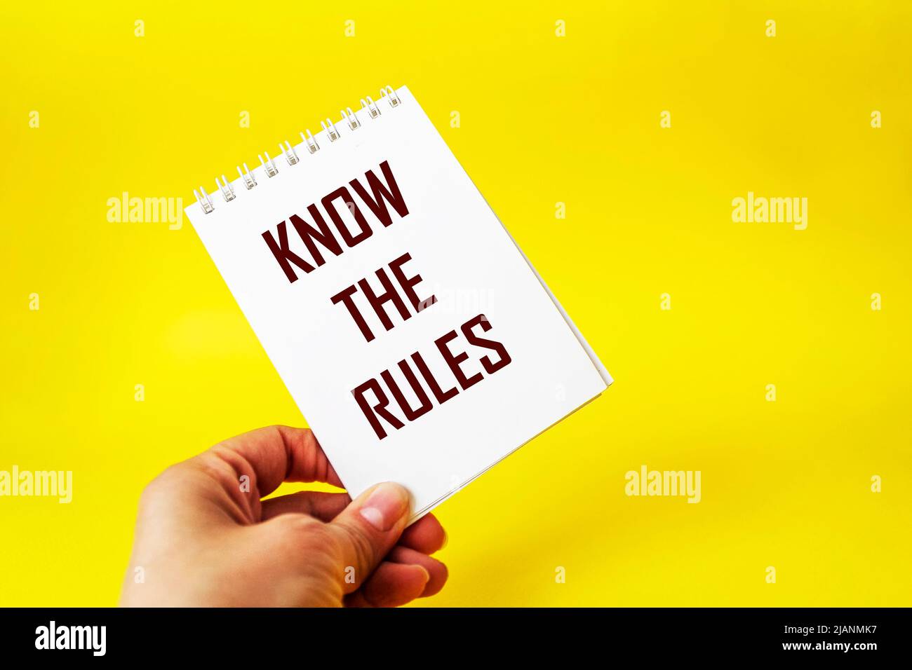 Business card in hand with the words I Know the Rules, on a yellow ...