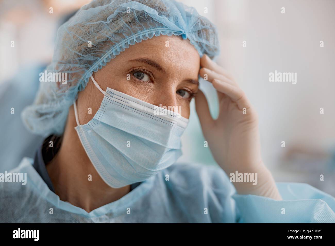 Close up of tired surgeon in mask standing in operating room after ...