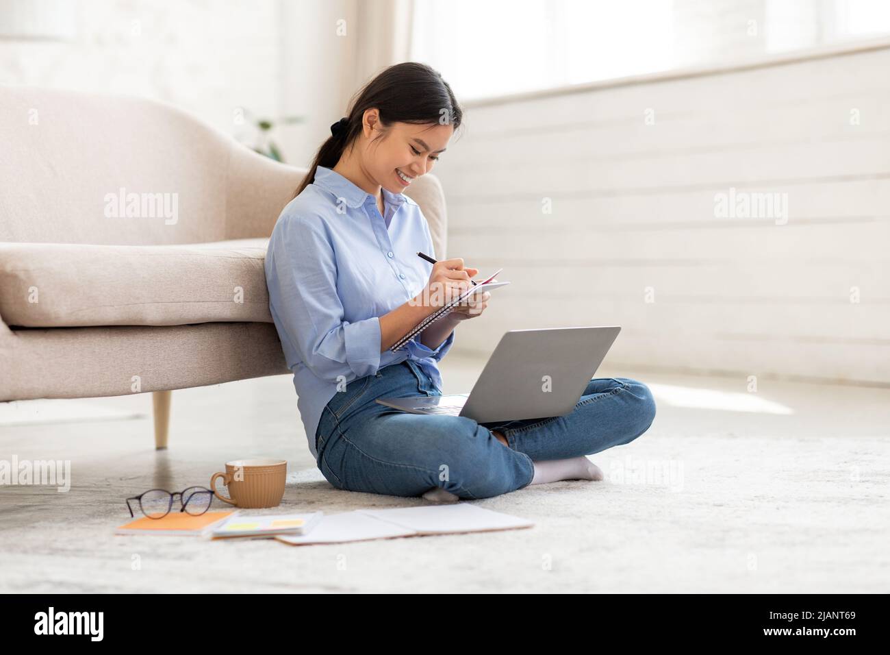 Chinese female student studying at home, using notebook Stock Photo - Alamy