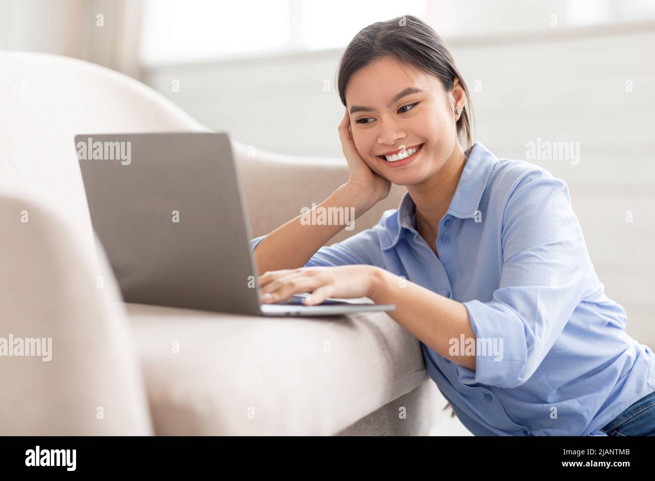 Closeup of smiling asian lady typing on notebook keyboard Stock Photo ...