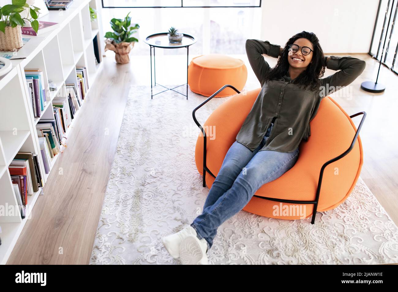Calm black woman having rest at home on the couch Stock Photo - Alamy