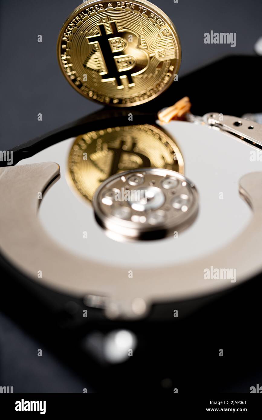 Gold bitcoin reflecting on hard drive platter of hard disk storage ...