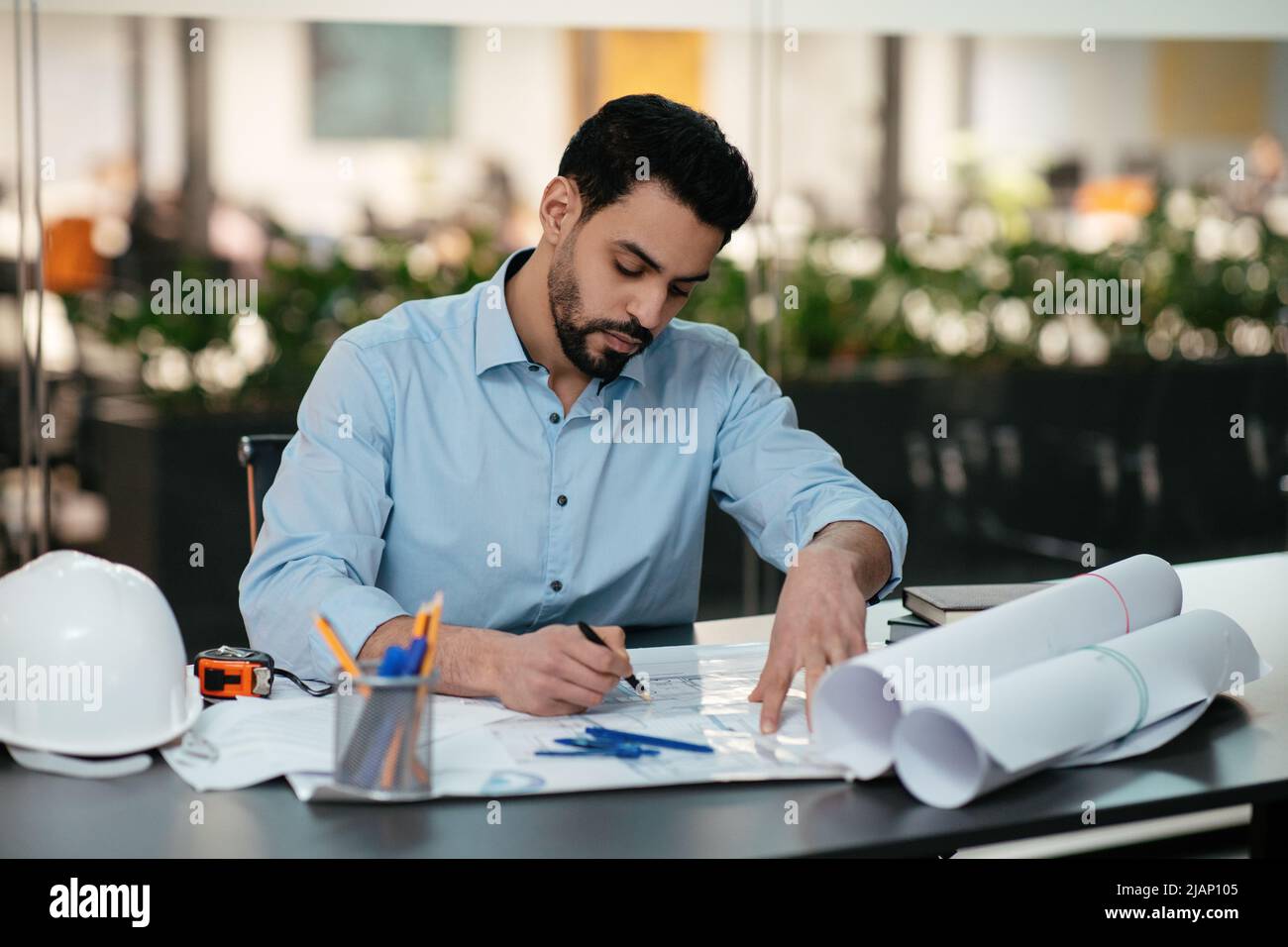 Serious smart busy young muslim man engineer architect with beard works ...