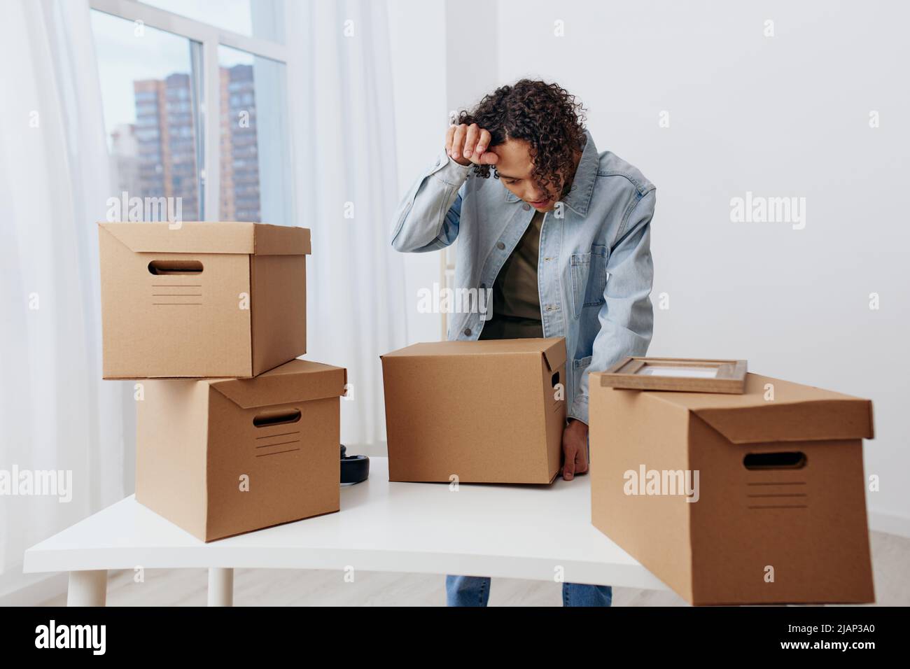 portrait of a man unpacking things from boxes in the room Lifestyle ...