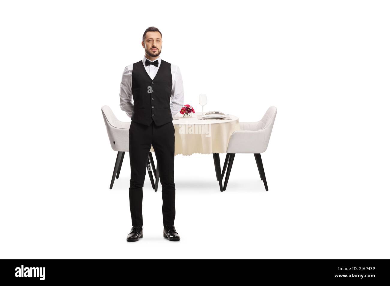 Full length portrait of a waiter with a bow tie standing in front of a ...