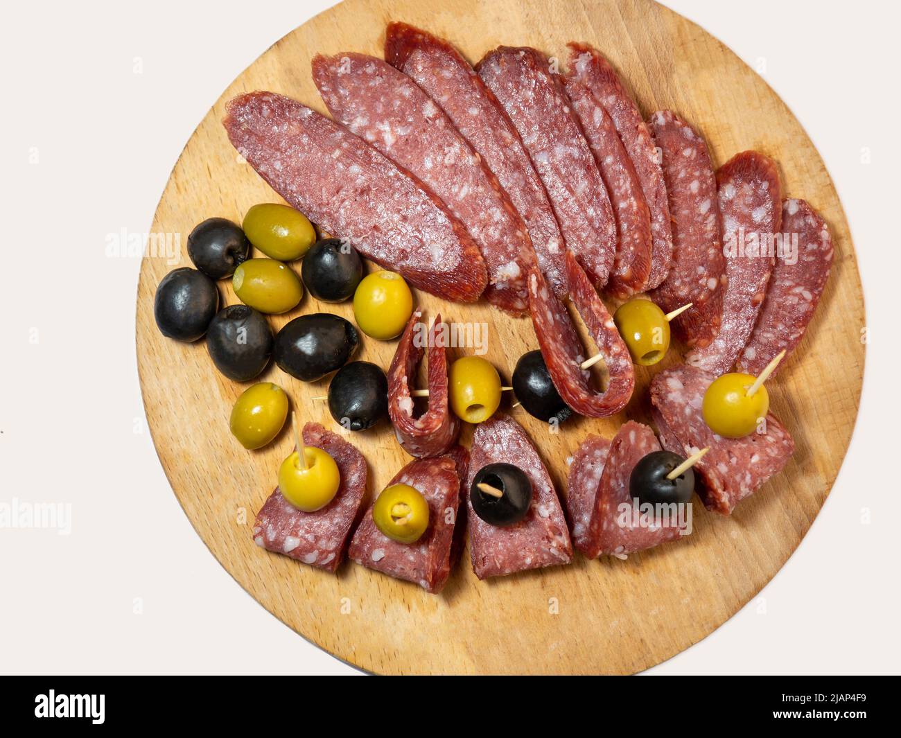 Slicing salami and olives on toothpicks. Slicing on a kitchen board ...