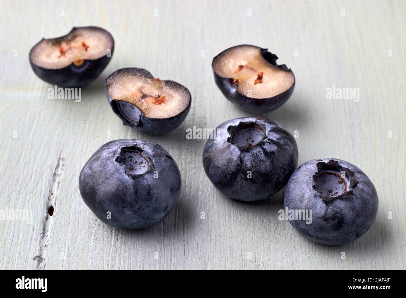 Several cut blueberries on a wooden blue background. Close-up Stock ...