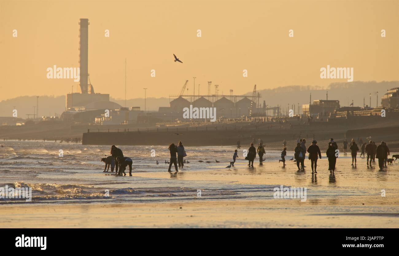 Silhouetted shapes of people on the beach at low tide, Brighton & Hove ...