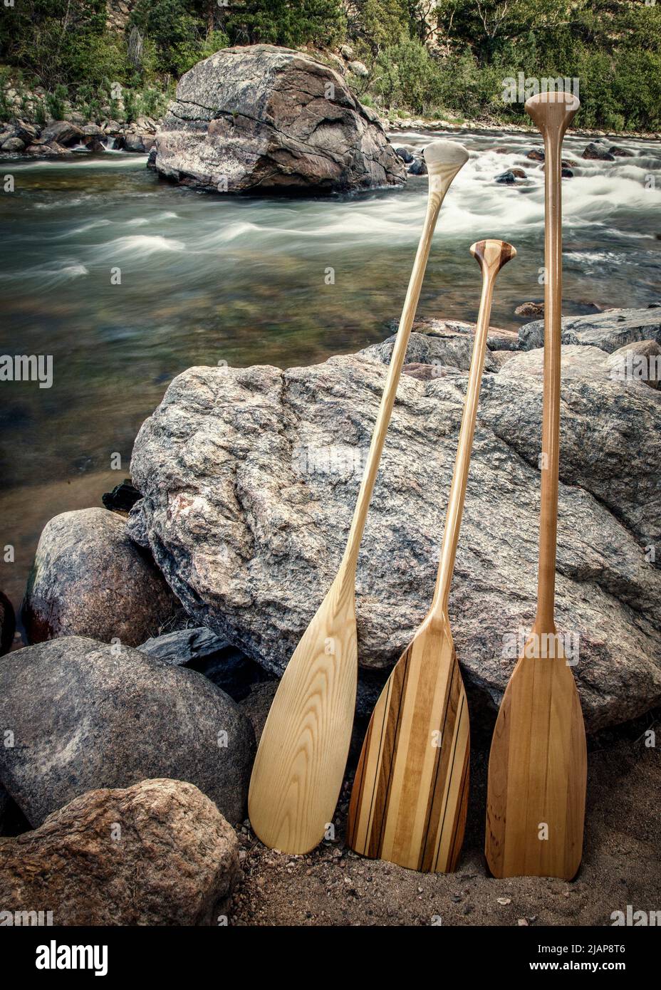 wooden canoe paddles on a rocky shore of mountain river - Cache la ...