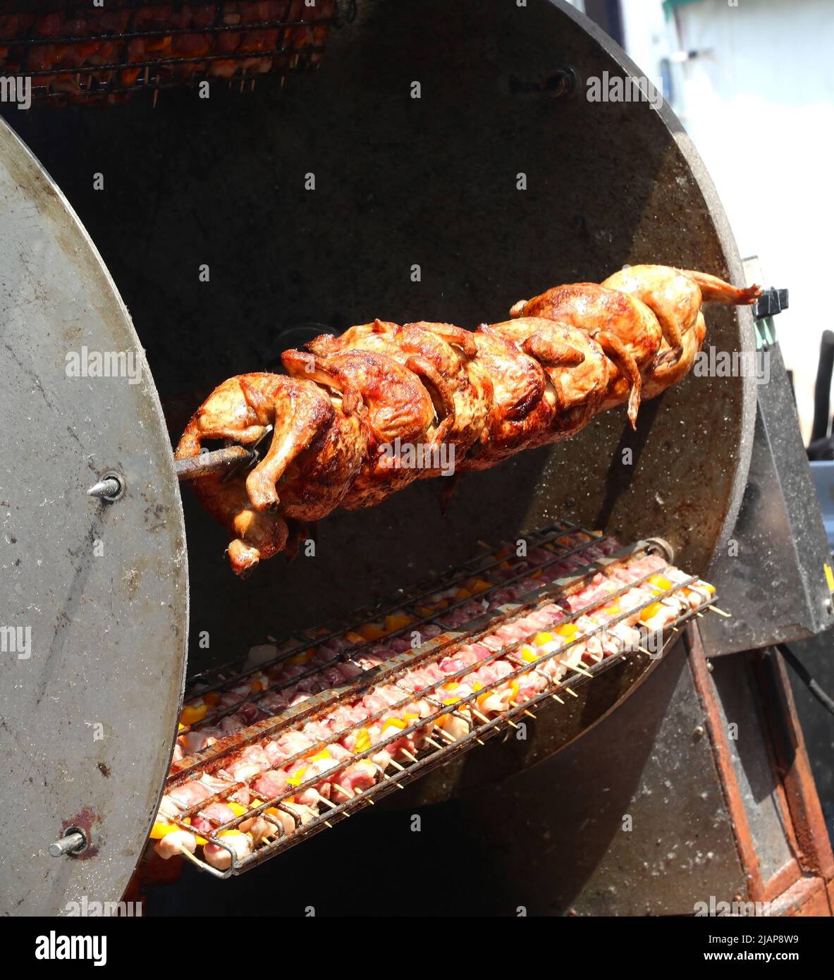 industrial rotisserie with spit-roasted chickens and skewers of meat ...