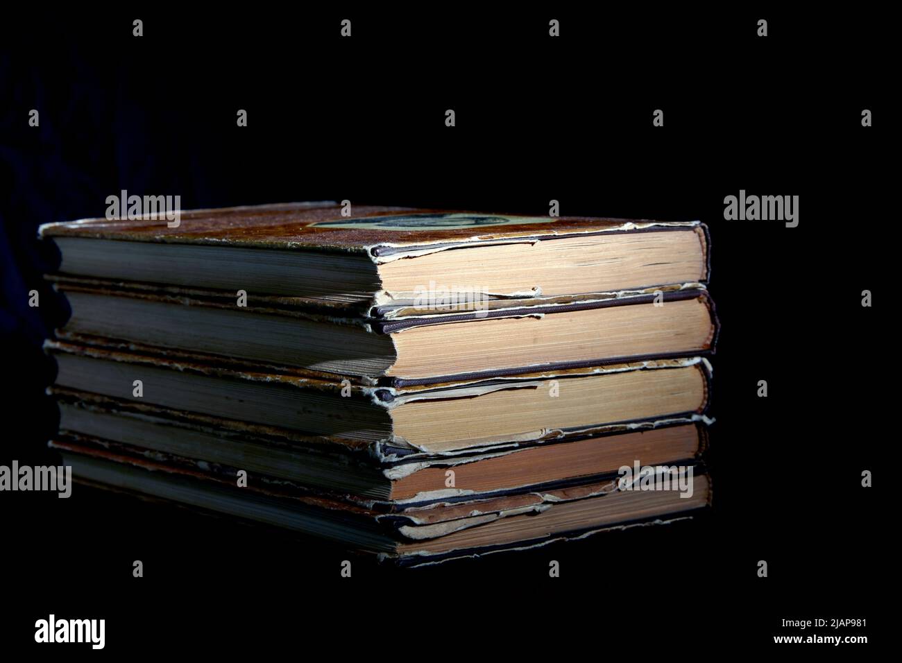 A stack of old dusty books on a dark background. Library at night Stock ...