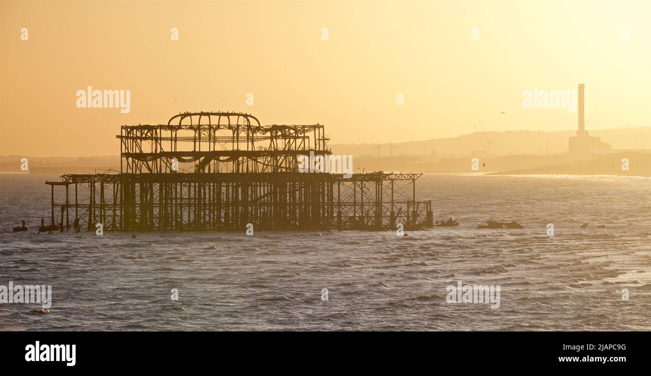 Silhouetted shapes of Brighton's ruined West Pier, and Shoreham Power ...