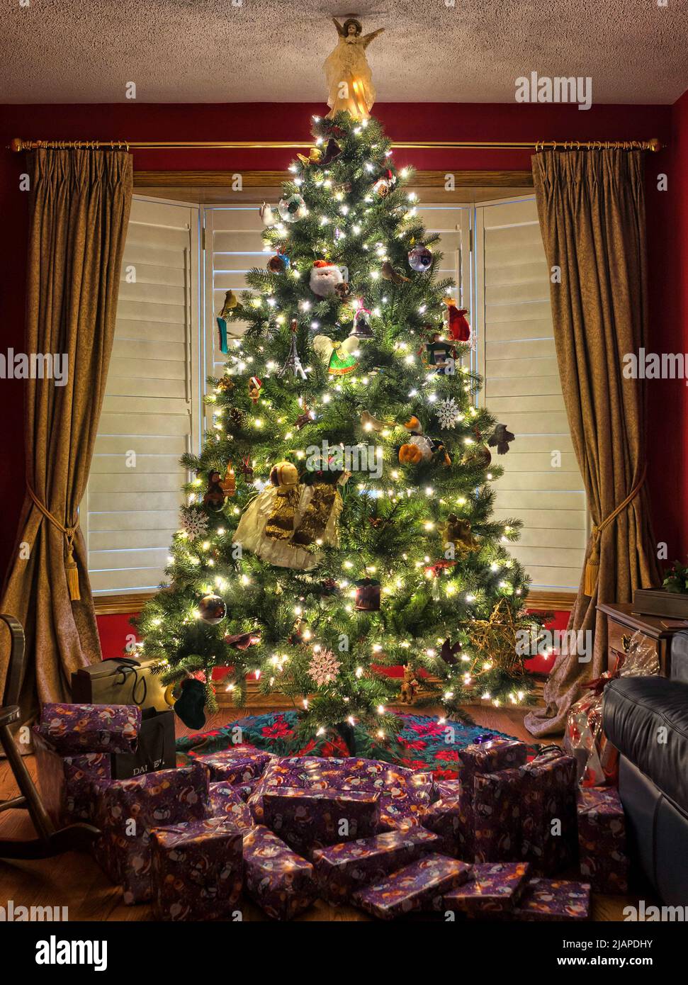 Christmas tree in front of a window with presents scattered below Stock ...